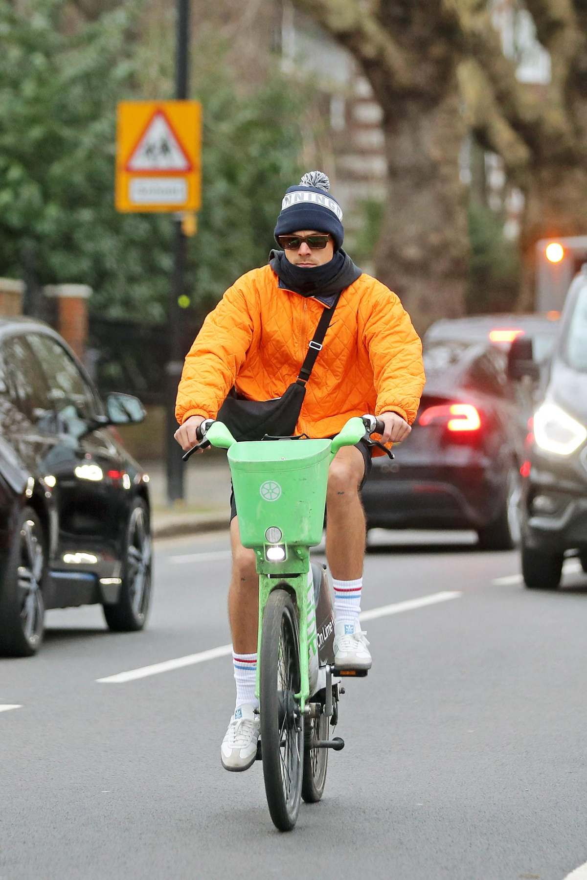 Harry Styles Rocks Neon Orange Jacket on Birthday Bike Ride | Us Weekly